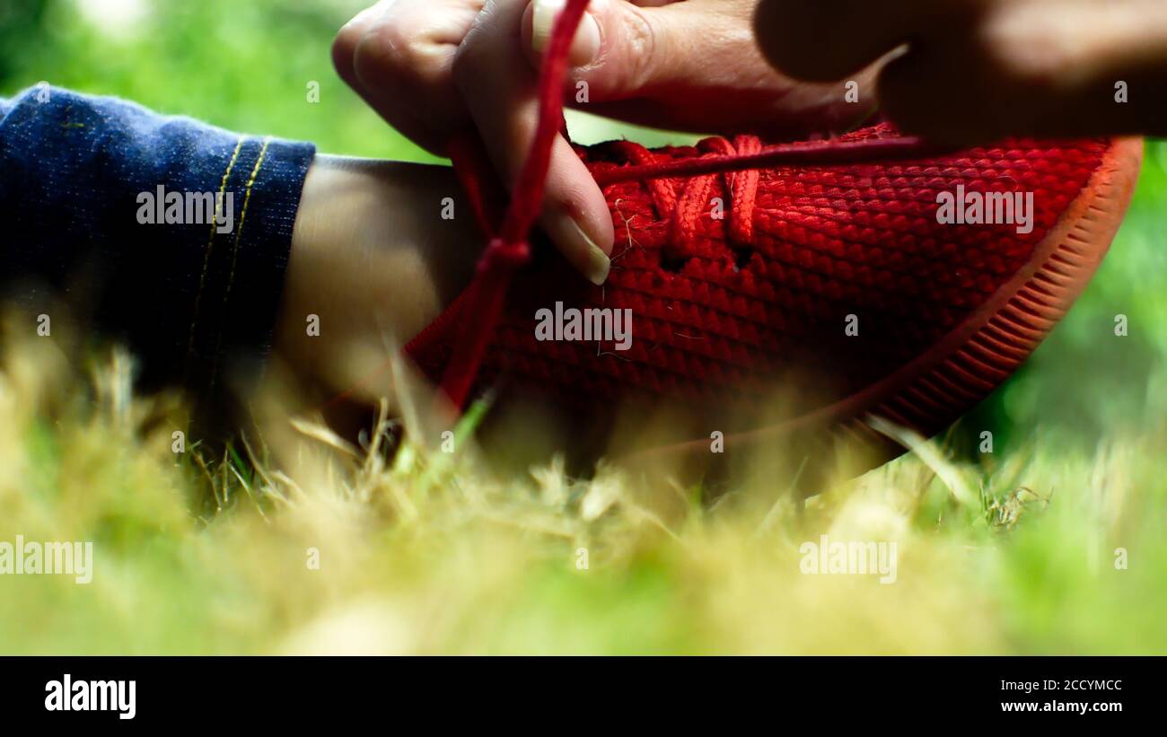 Closeup of hands fastening shoe ties - care concept Stock Photo - Alamy