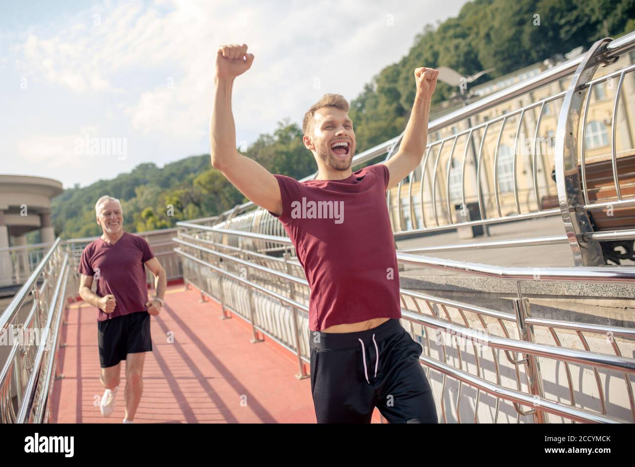 Young bearded male raising both hands, winning running race Stock Photo ...