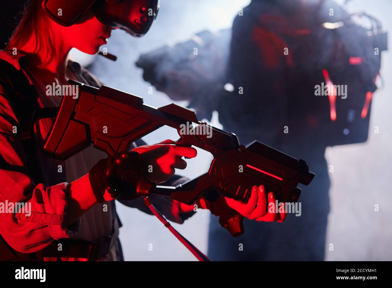 Side view on woman holding special gun for virtual game, big weapon ...