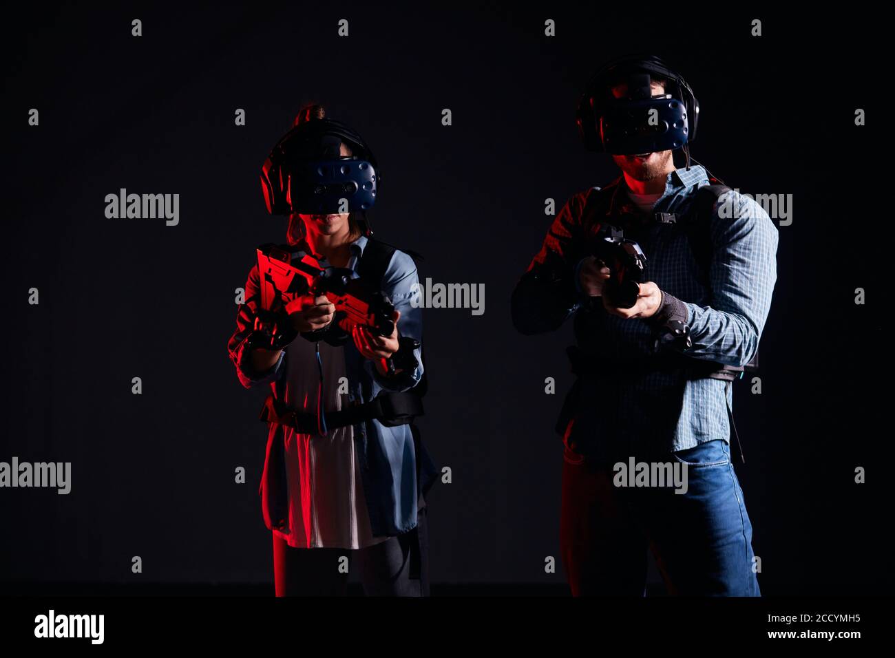 Youg couple direct their virtual weapons at camera, in search of enemy ...