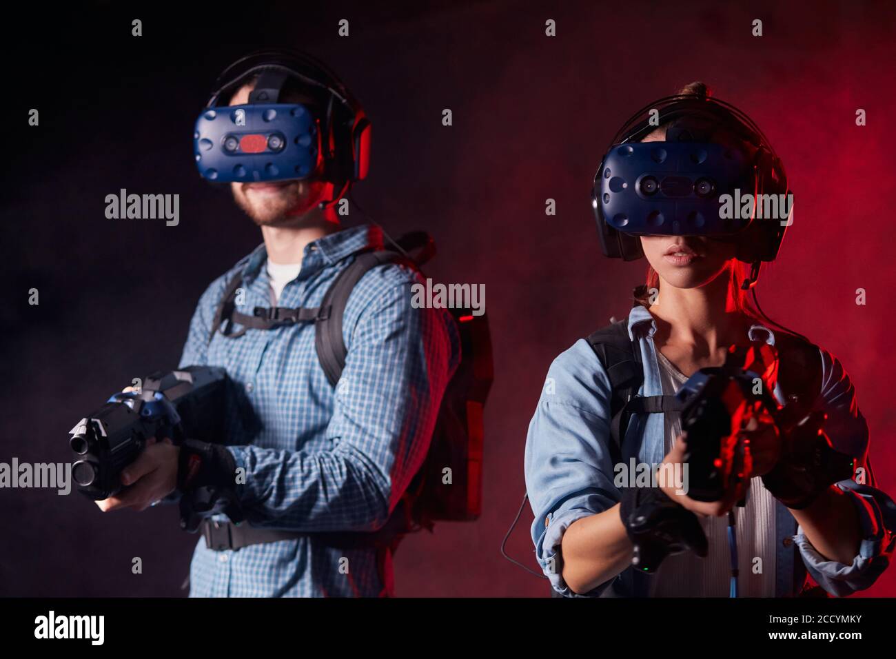 Man and woman with vr guns and headsets standing isolated black ...
