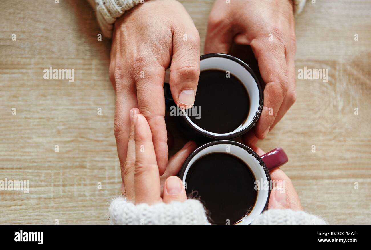 Two hands are touching while drinking coffee as a concept of affection ...
