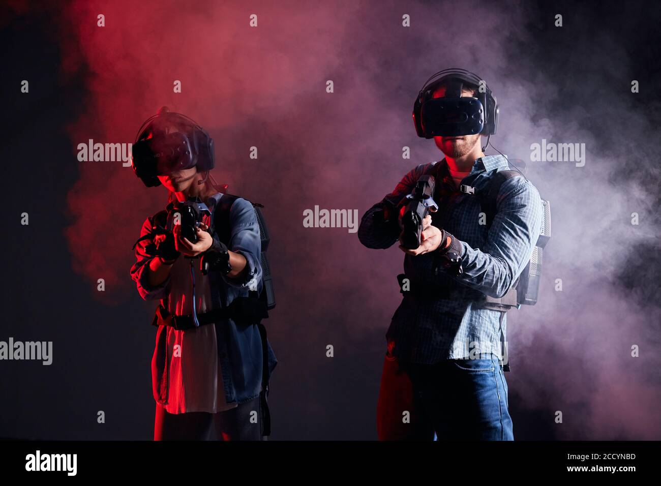 Youg couple direct their virtual weapons at camera, in search of enemy ...