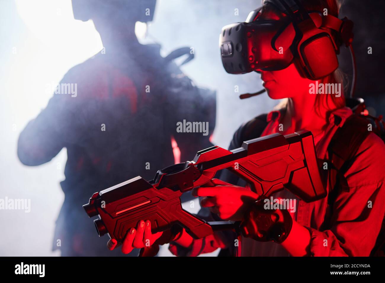 Side view on woman holding special gun for virtual game, big weapon ...