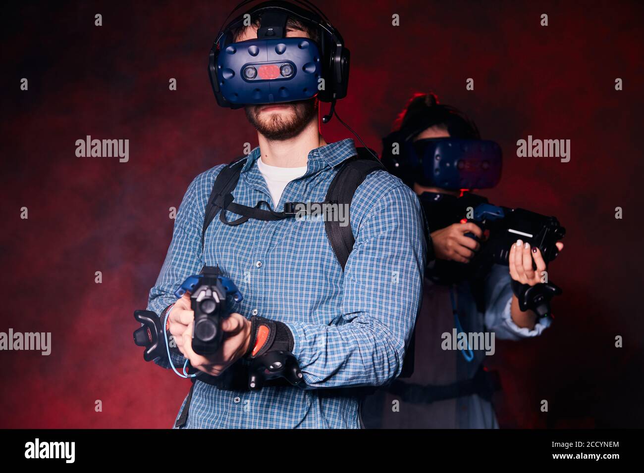 Neon backlit background. Isolated. Two young people stand back to back ...