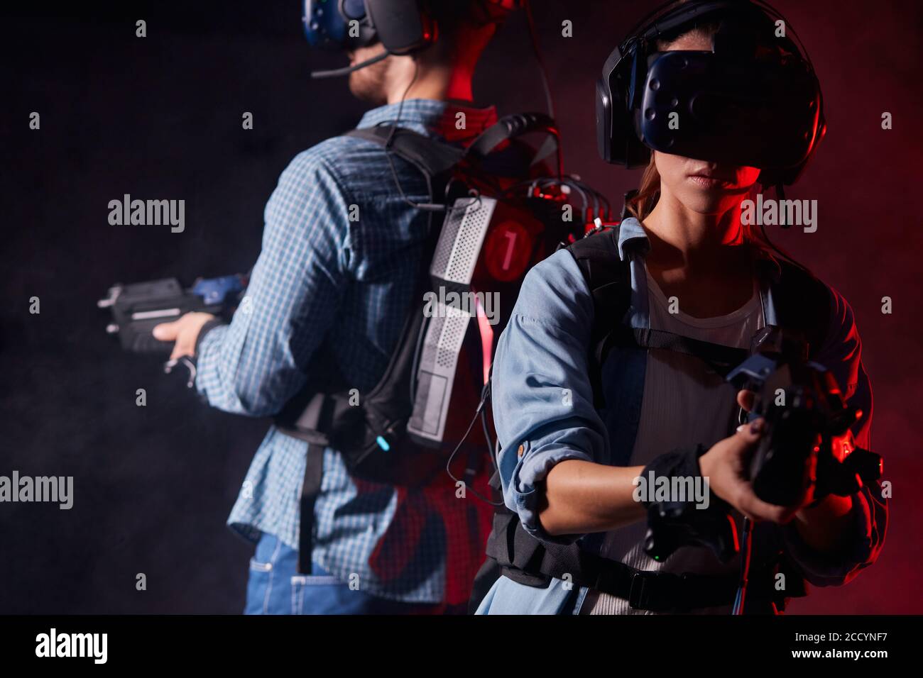 Neon backlit background. Isolated. Two young people stand back to back ...