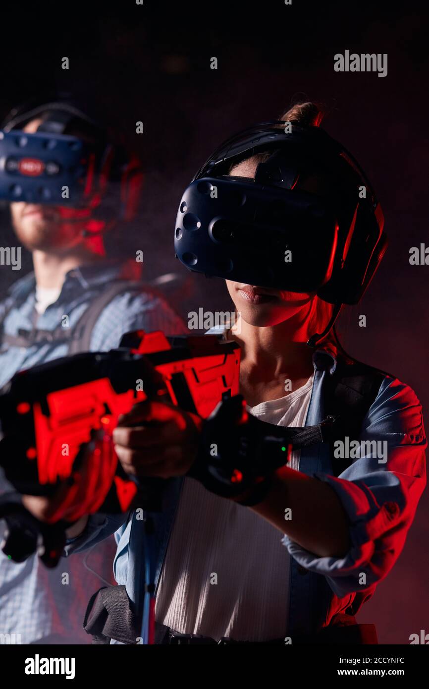 Portrait of woman playing virtual game with his boyfriend, hold vr guns ...
