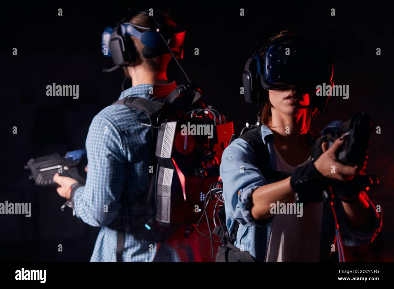 Neon backlit background. Isolated. Two young people stand back to back ...