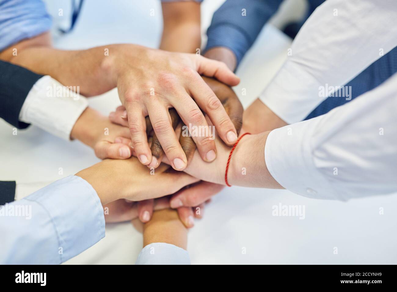 Managers stack many hands in business team building meeting Stock Photo ...