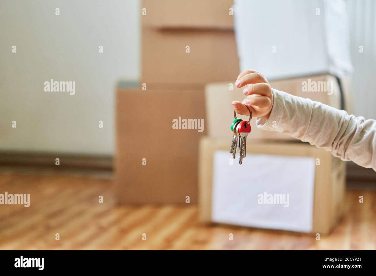 Child holds the house key in one hand as a symbol of moving into the ...