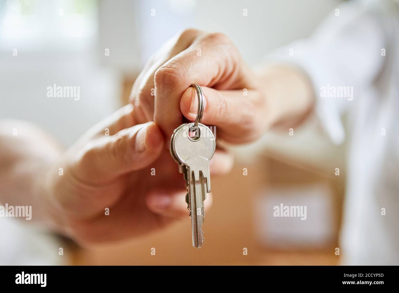 Hands of couple hold keys to new house after moving Stock Photo - Alamy
