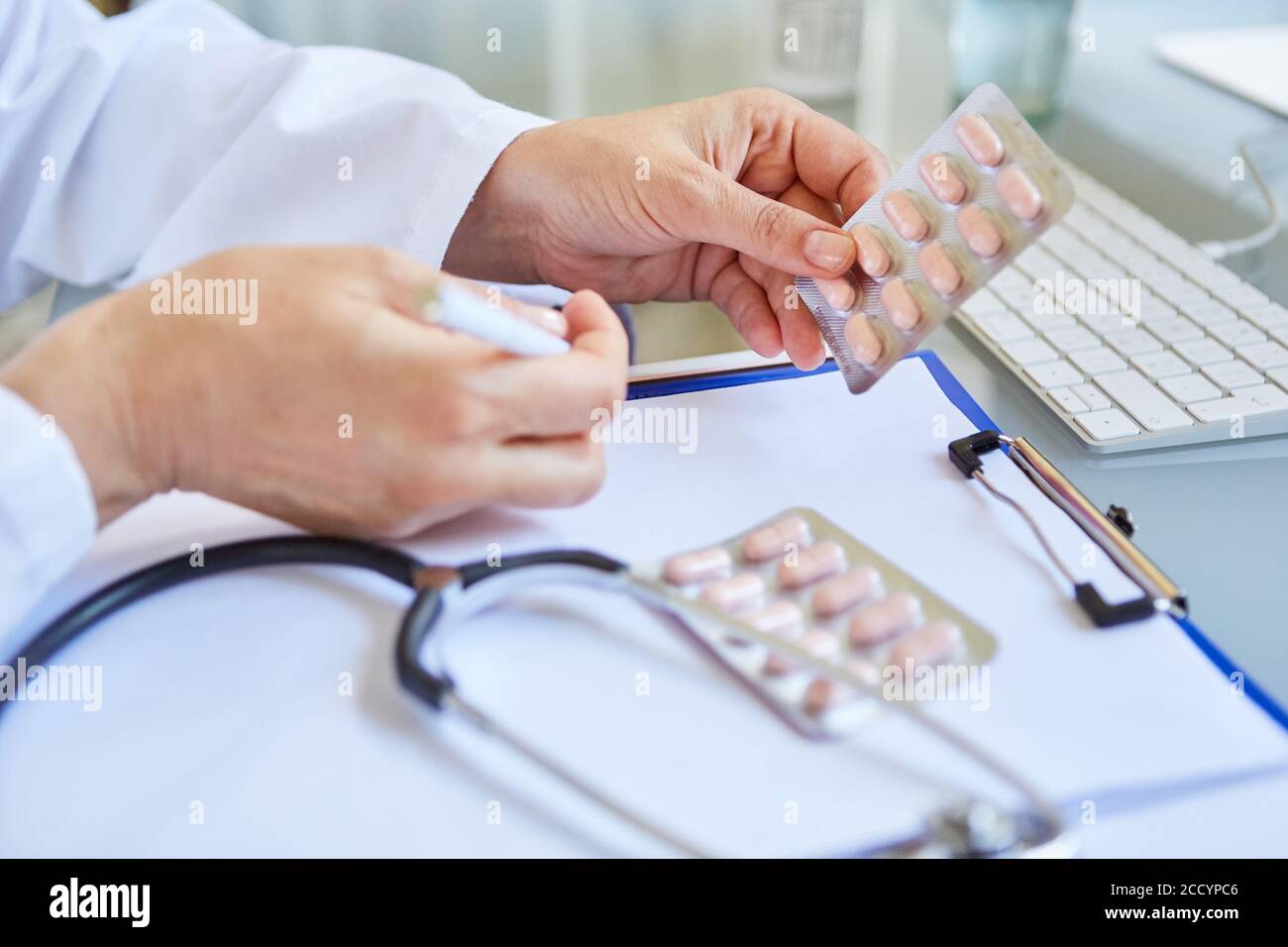 Doctor with pen and clipboard prescribes prescription drug in ...