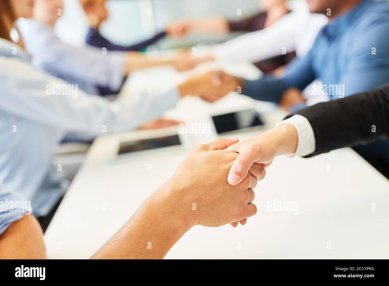 Business people greet each other with a handshake in a business meeting ...