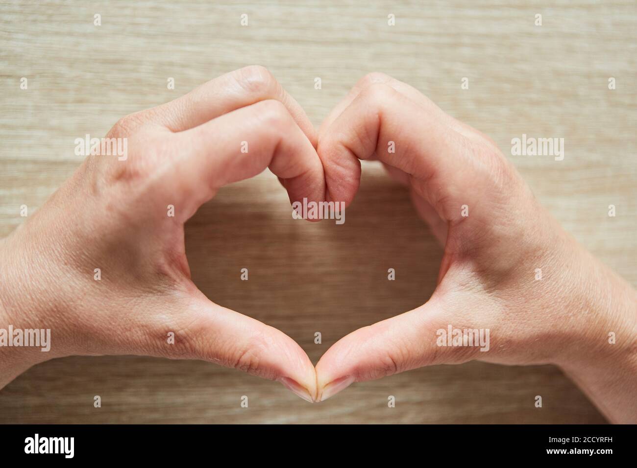 Person shapes their hands and fingers into a heart on Valentine's Day ...