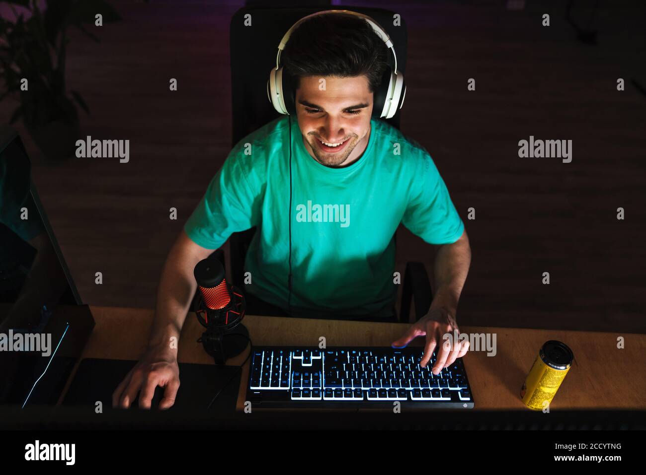 Image of caucasian happy man in headphones playing video game on ...