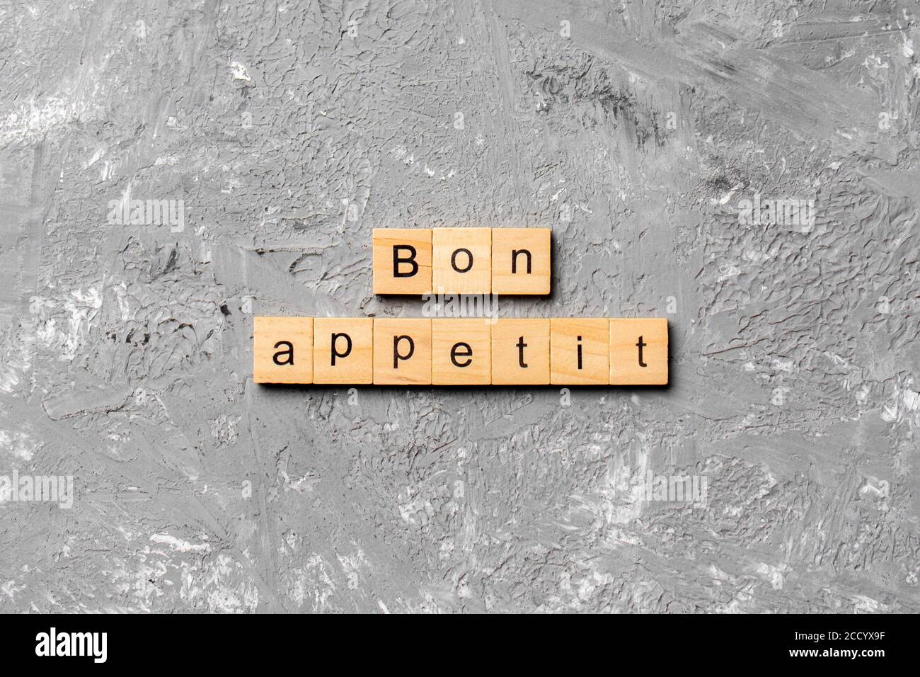 Bon Appetit word written on wood block. Bon Appetit text on cement ...