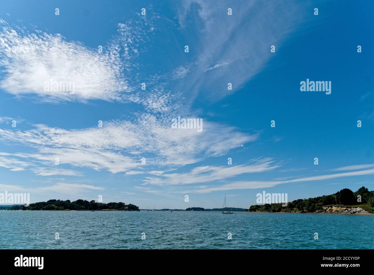 Blue sky and light fair weather clouds above Brownsea Island in Poole ...