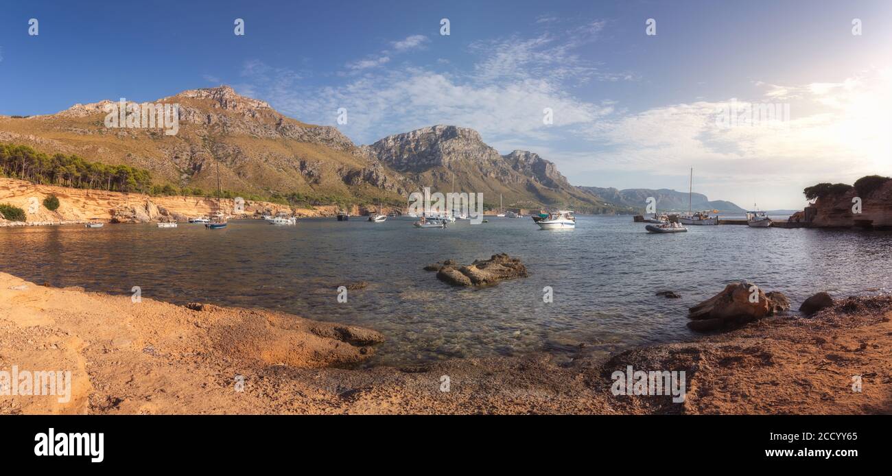 Typical Spanish beach with boats and yachts on clear water surrounded ...