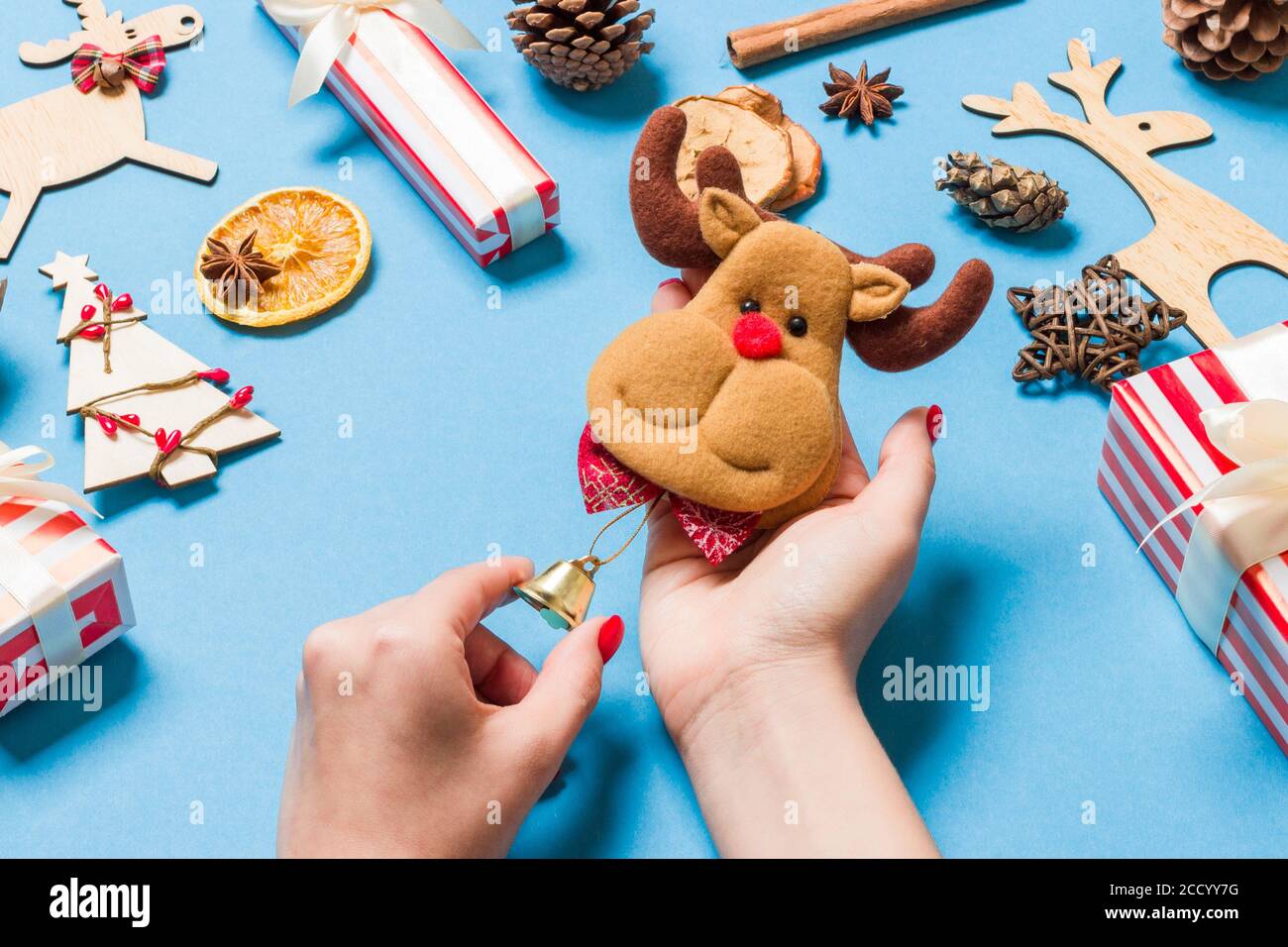 Top view of reindeer in female hands on blue background. Christmas ...