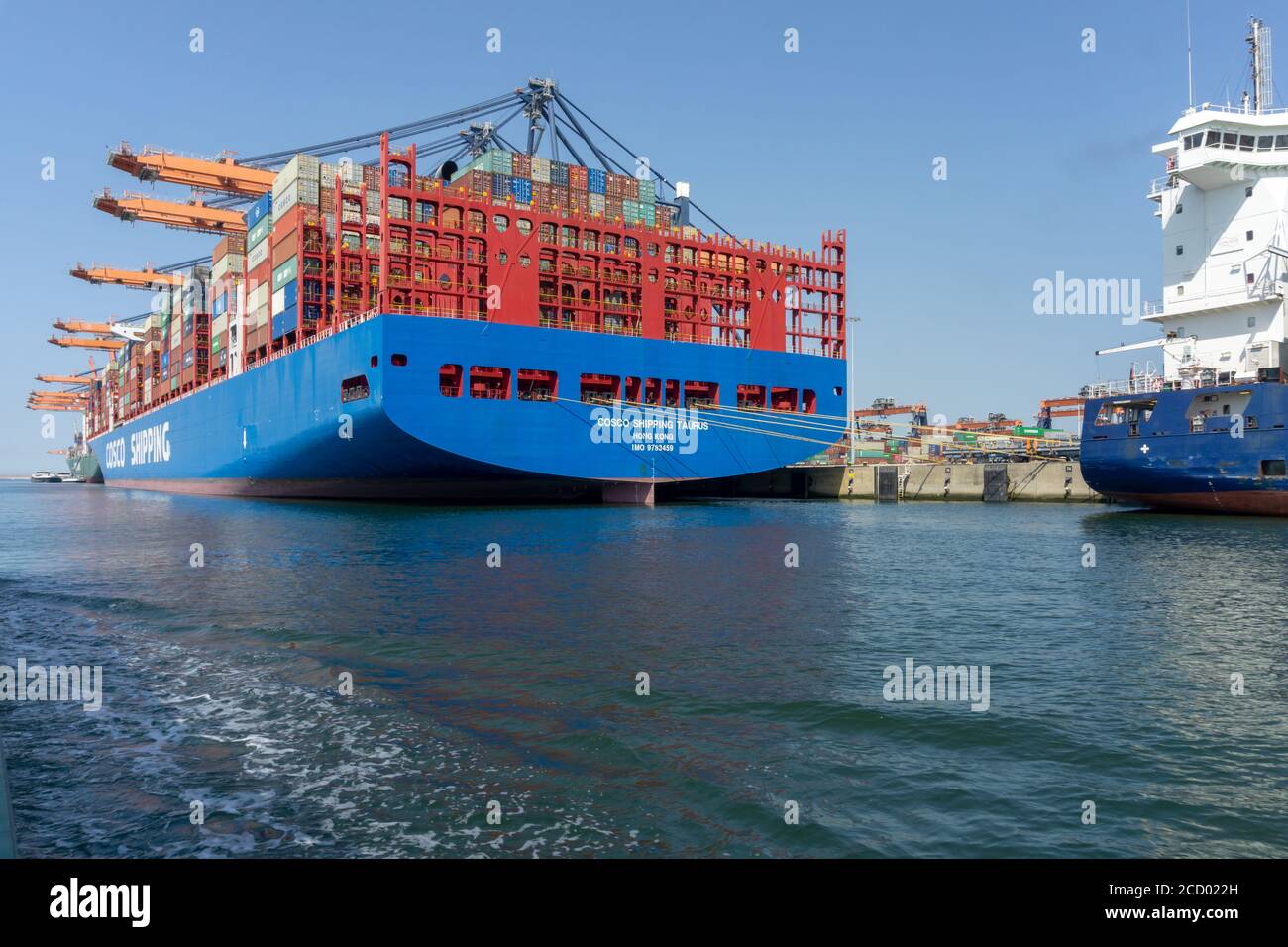 Rear view of container ship Cosco Shipping Taurus with smaller vessel ...