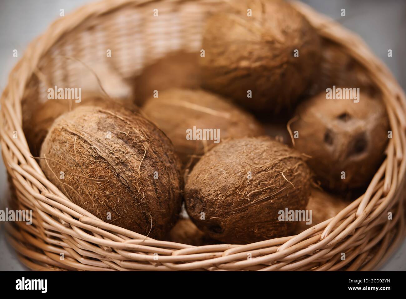 In a wicker basket are exotic coconut fruits in a strong shell and ...