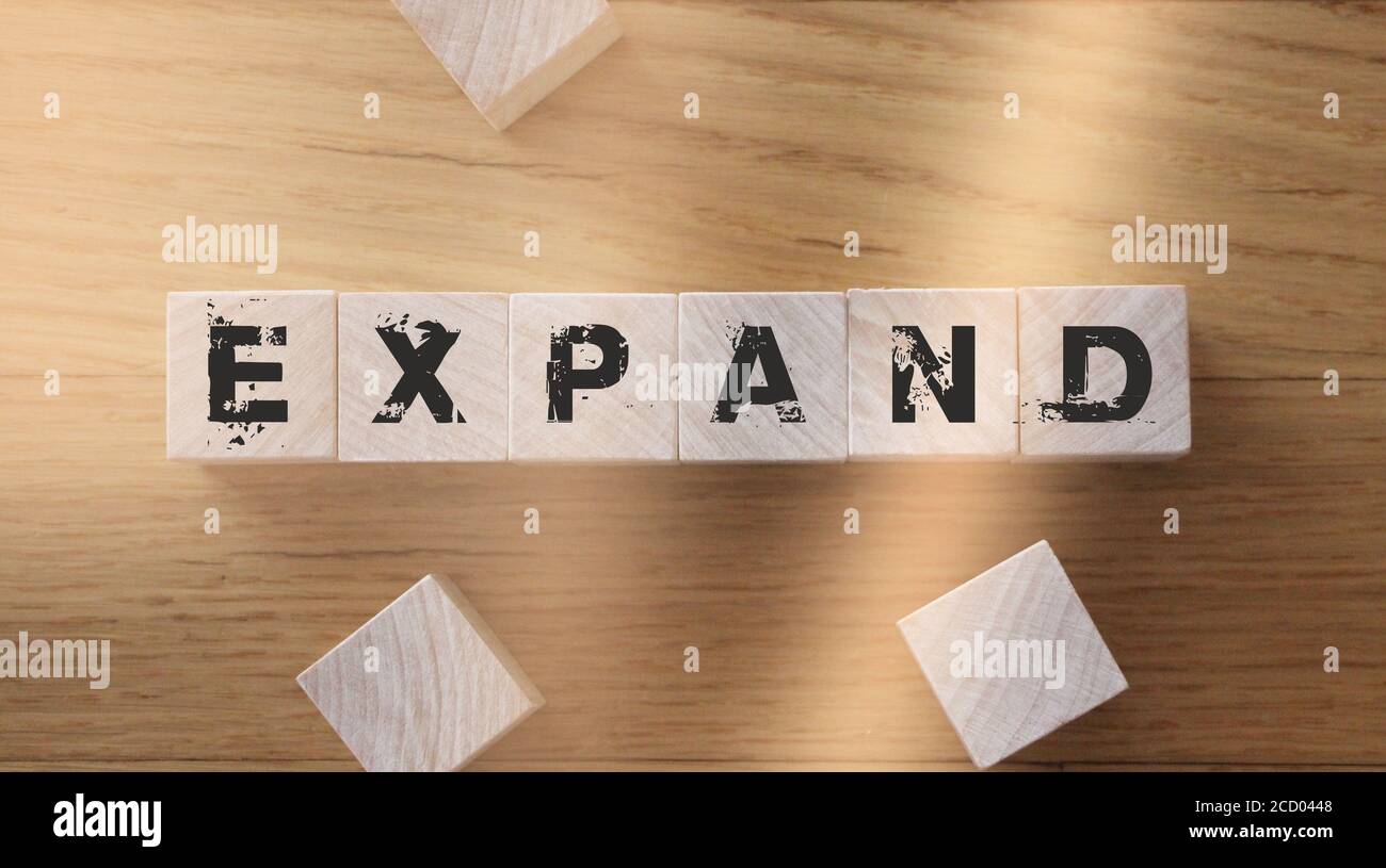 EXPAND word written on wood block. EXPAND text on wooden table for your ...