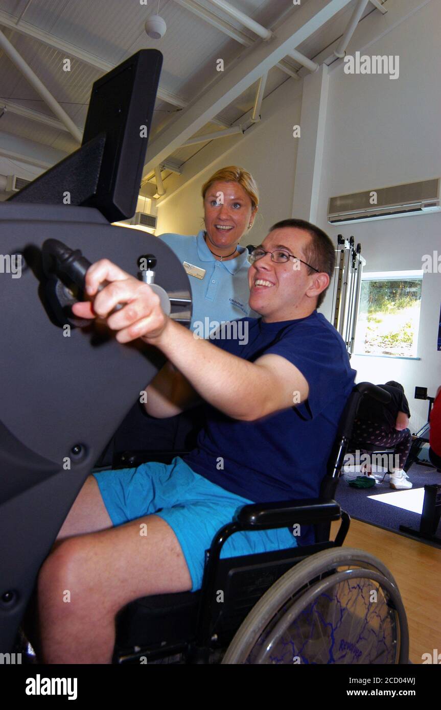 Disabled man in wheelchair using new gym facilities especially adapted ...