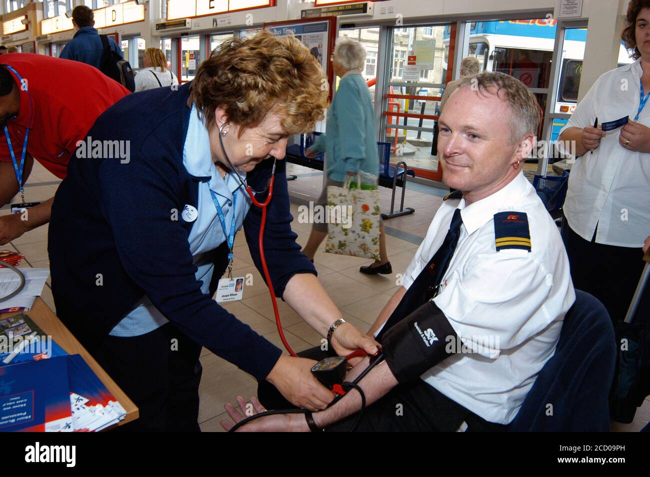 Community nurse carries out blood pressure tests on public & bus ...