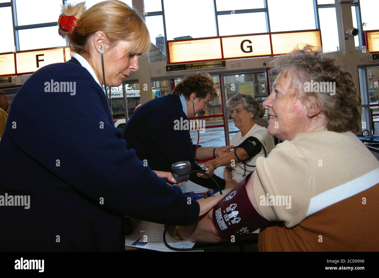 Community nurse carries out blood pressure tests on public & bus ...
