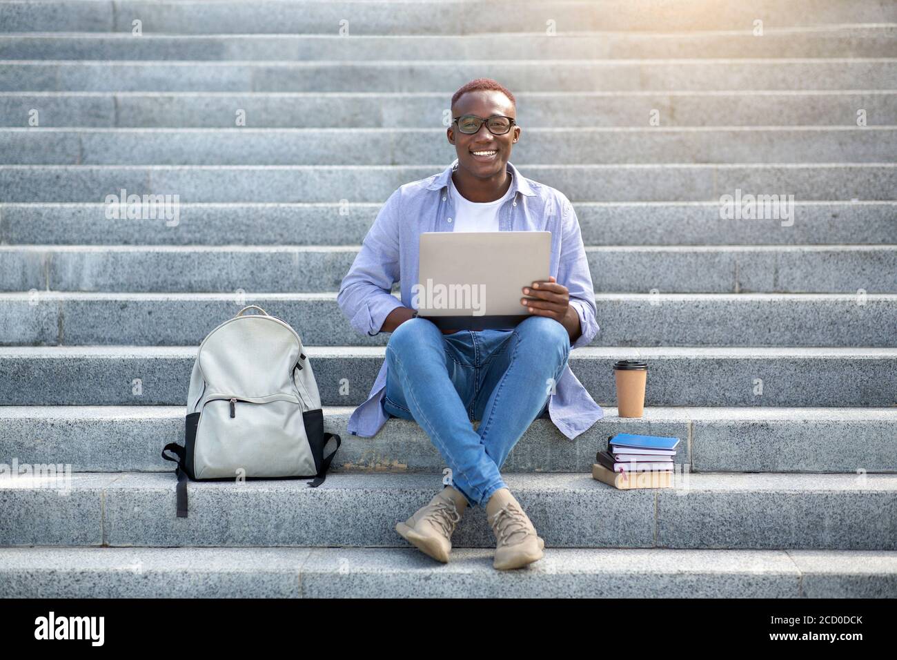 Online education. Intelligent black man with laptop and pile of books ...