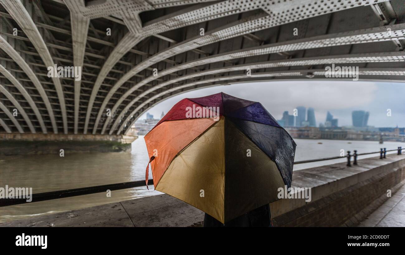 Sheltering from the rain under Blackfriars Bridge in London Stock Photo ...