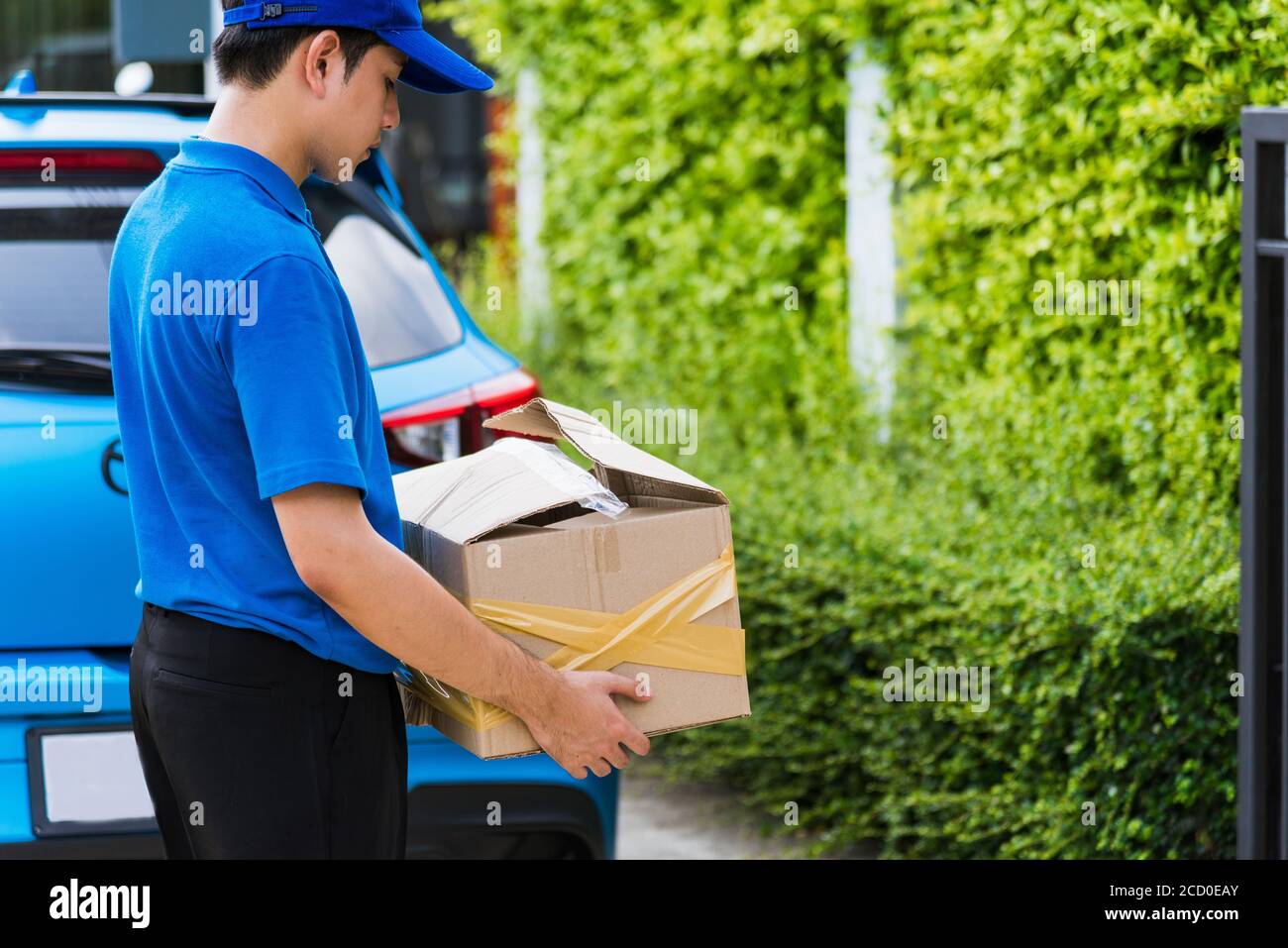 Asian young delivery man in blue uniform he emotional falling courier ...
