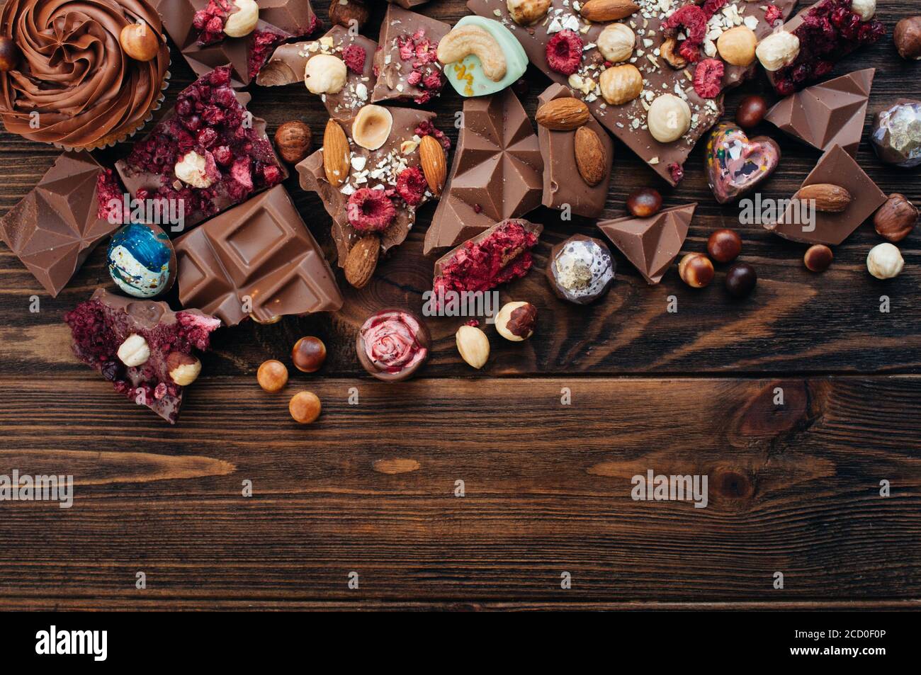 Broken bars of milk chocolate with nuts and sublimated berries and ...