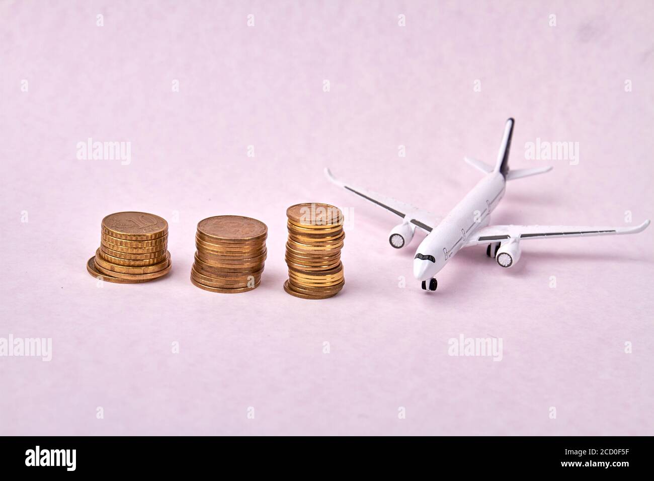 Rising stack of coins and toy model of a plane Stock Photo - Alamy