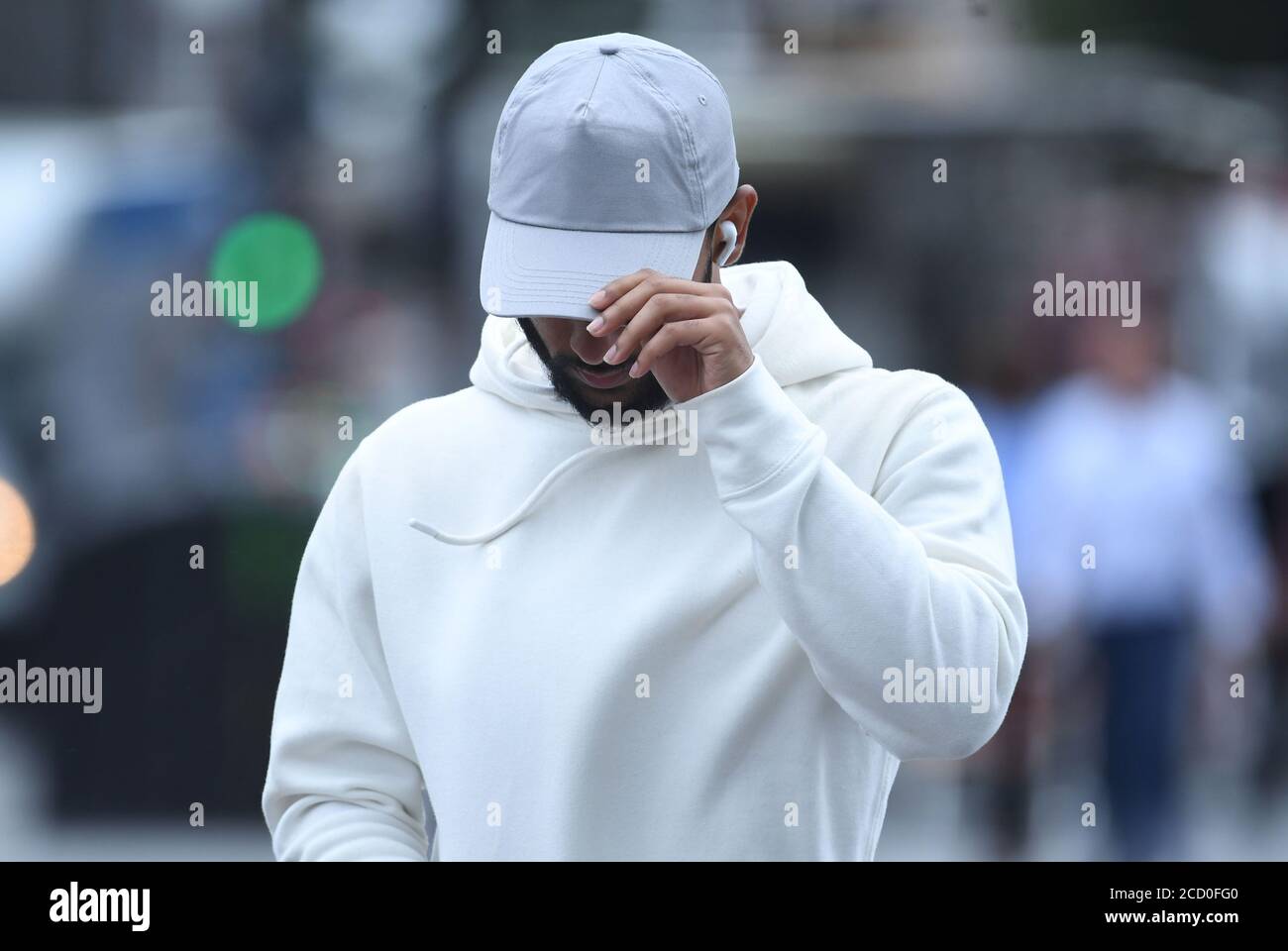 A man holds onto his hat in the wind at Euston Circus in London Stock ...