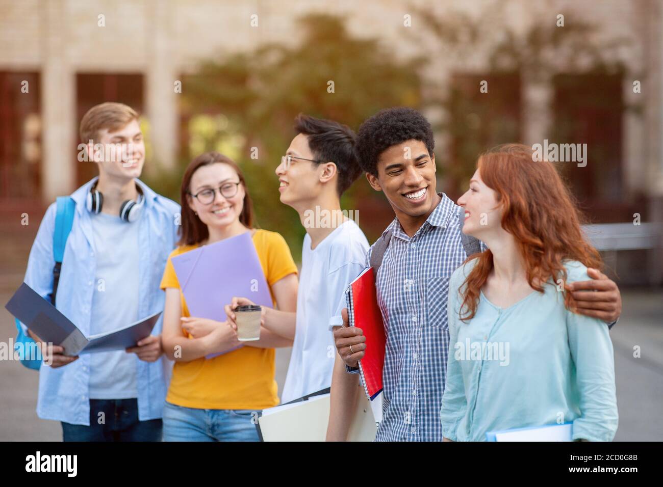 Five multiracial students walking together near campus Stock Photo - Alamy