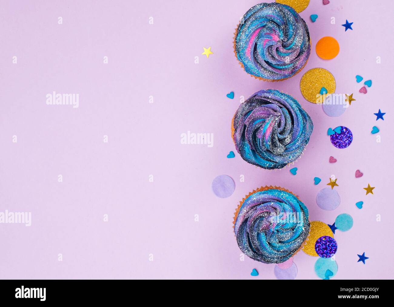 Vanilla cupcakes with galaxy dark whipped cream on violet party ...