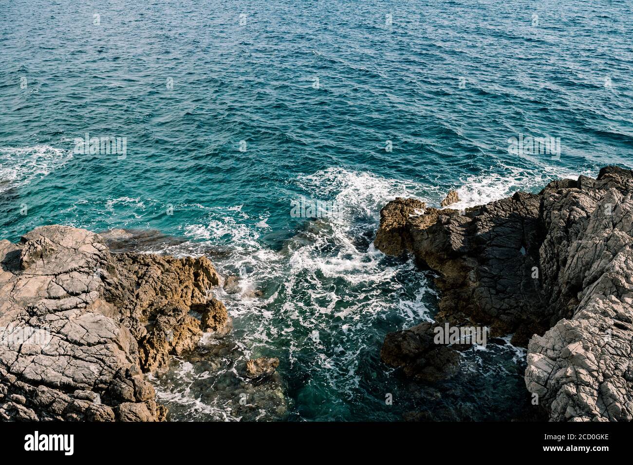Rocks in the sea, waves hitting rocks Stock Photo - Alamy