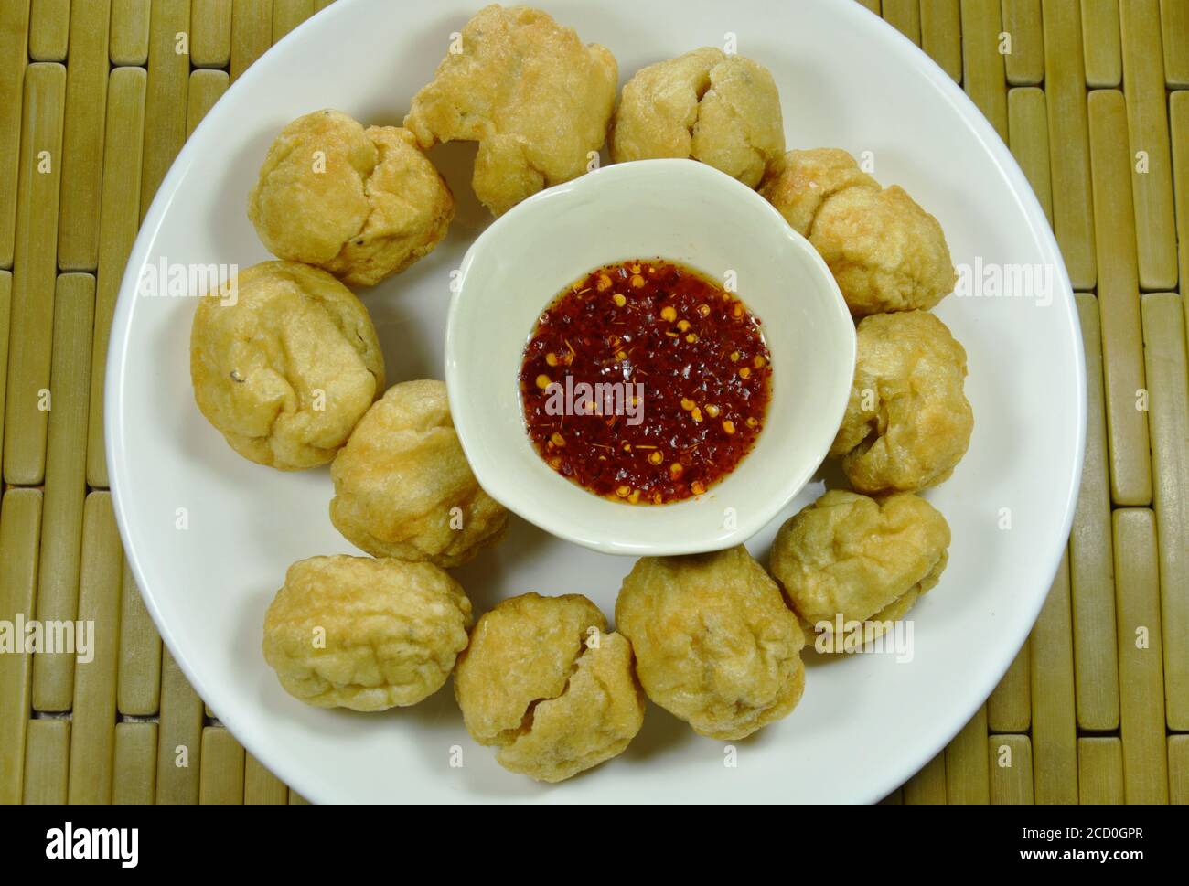 crispy fried fish ball dipping with spicy and sweet sauce cup on plate ...