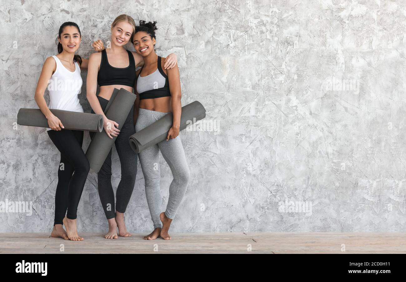 Fitness And Pilates. Beautiful Fit Girls With Yoga Mats Over Gray Wall ...