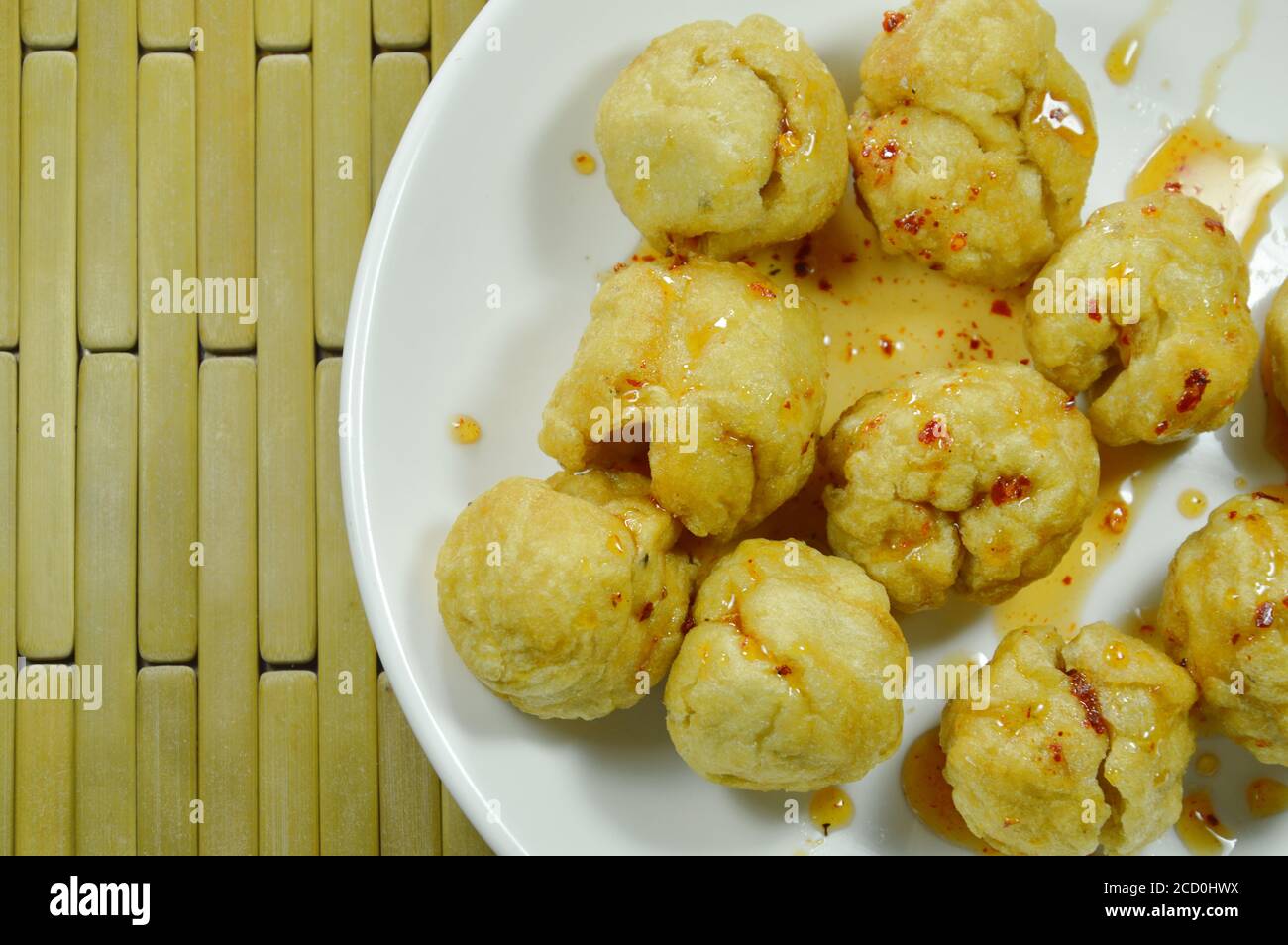 crispy fried fish ball dipping with spicy and sweet sauce cup on plate ...