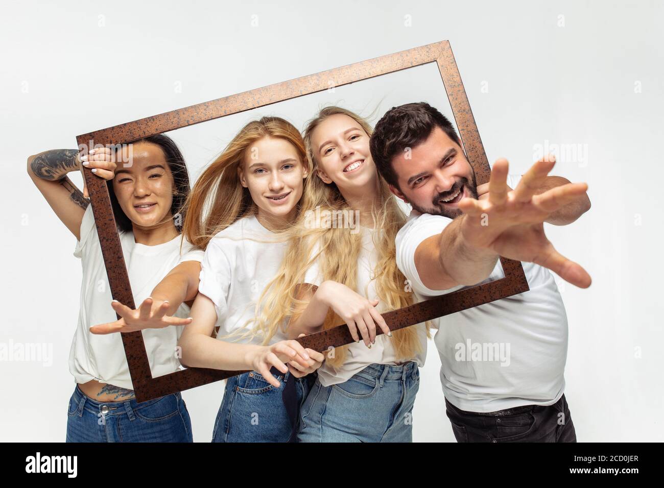 Photo frame. Group of adorable multiethnic friends having fun on white ...