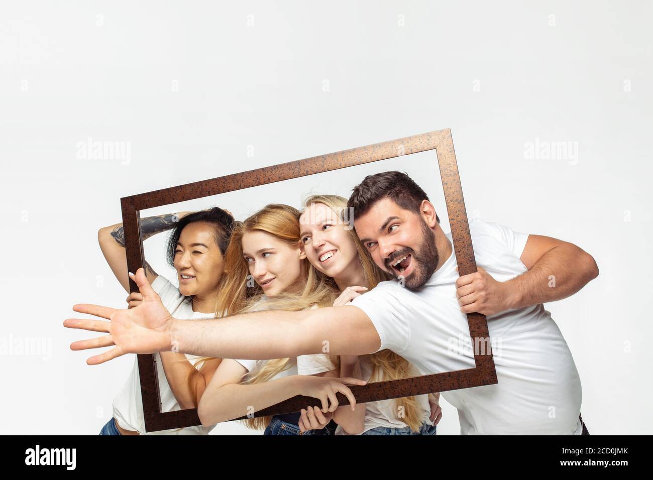 Photo frame. Group of adorable multiethnic friends having fun on white ...