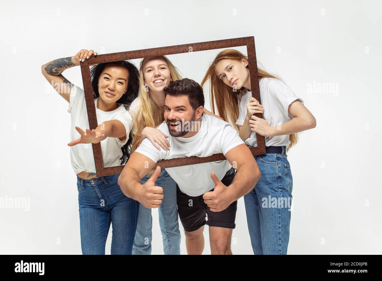 Photo frame. Group of adorable multiethnic friends having fun on white ...