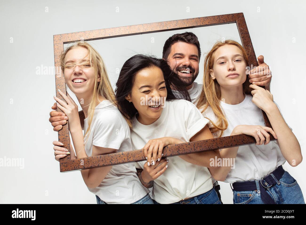Photo frame. Group of adorable multiethnic friends having fun on white ...