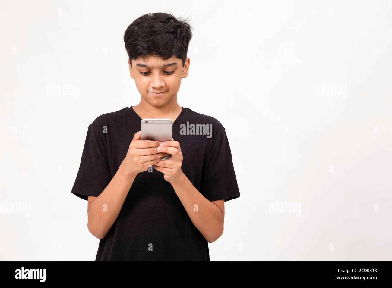Young Indian boy using mobile phone. Cute teenager checks social media ...