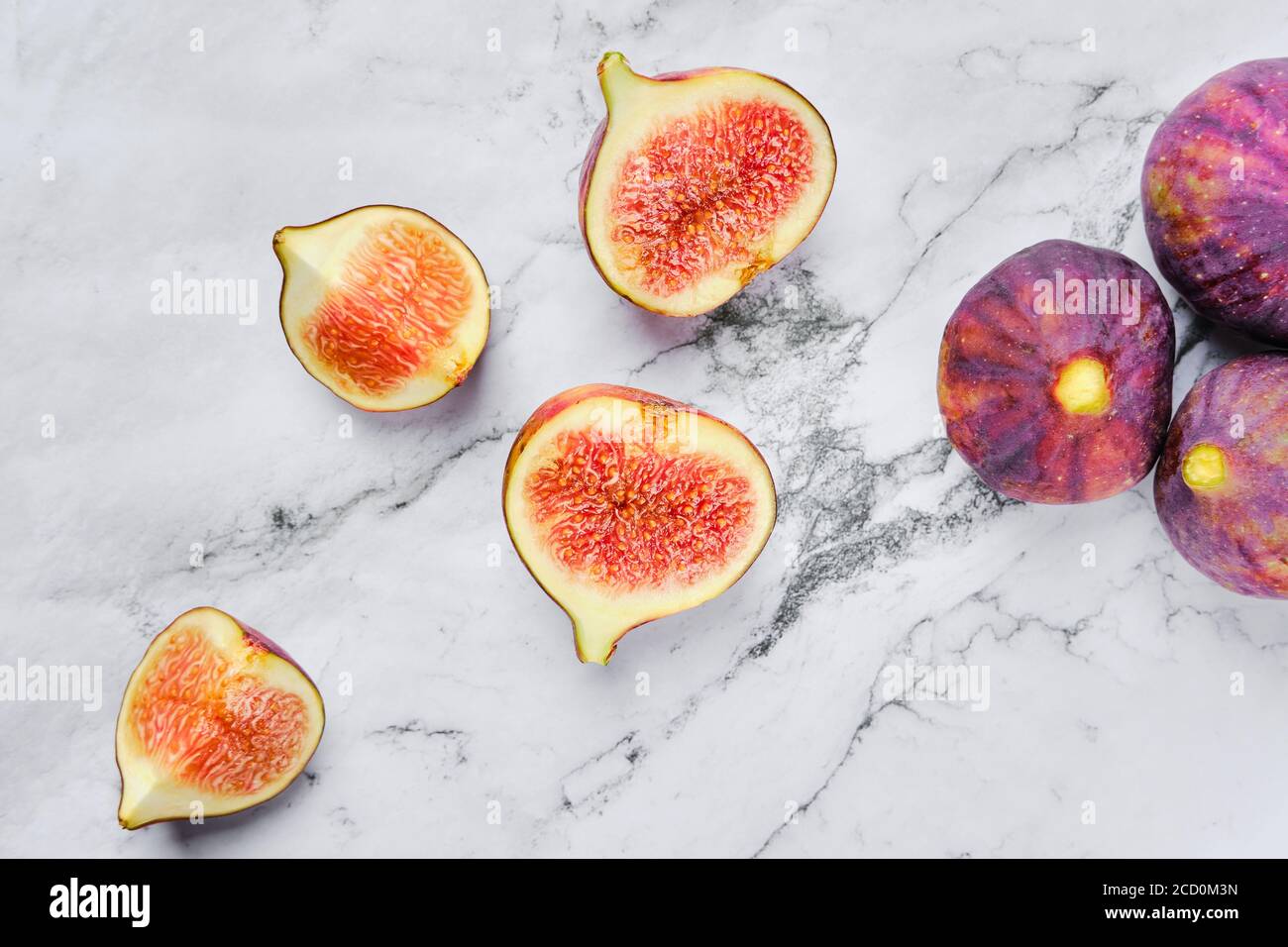 Top view of fresh figs, whole and cut on slices on marble plate Stock ...