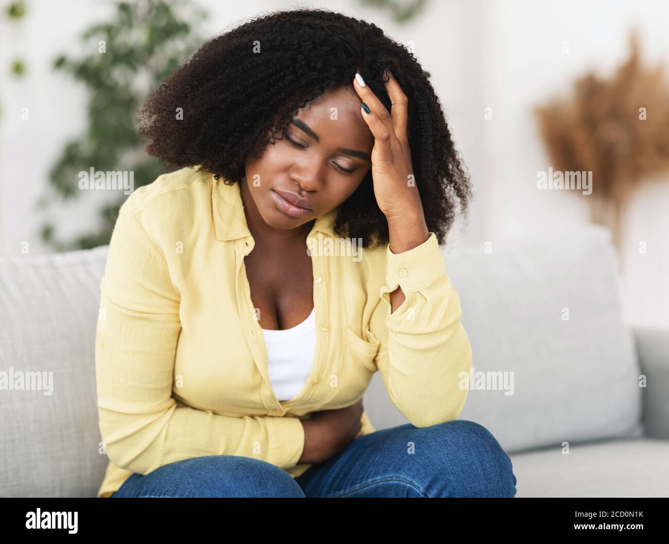 Tired african american woman suffering from pain Stock Photo - Alamy