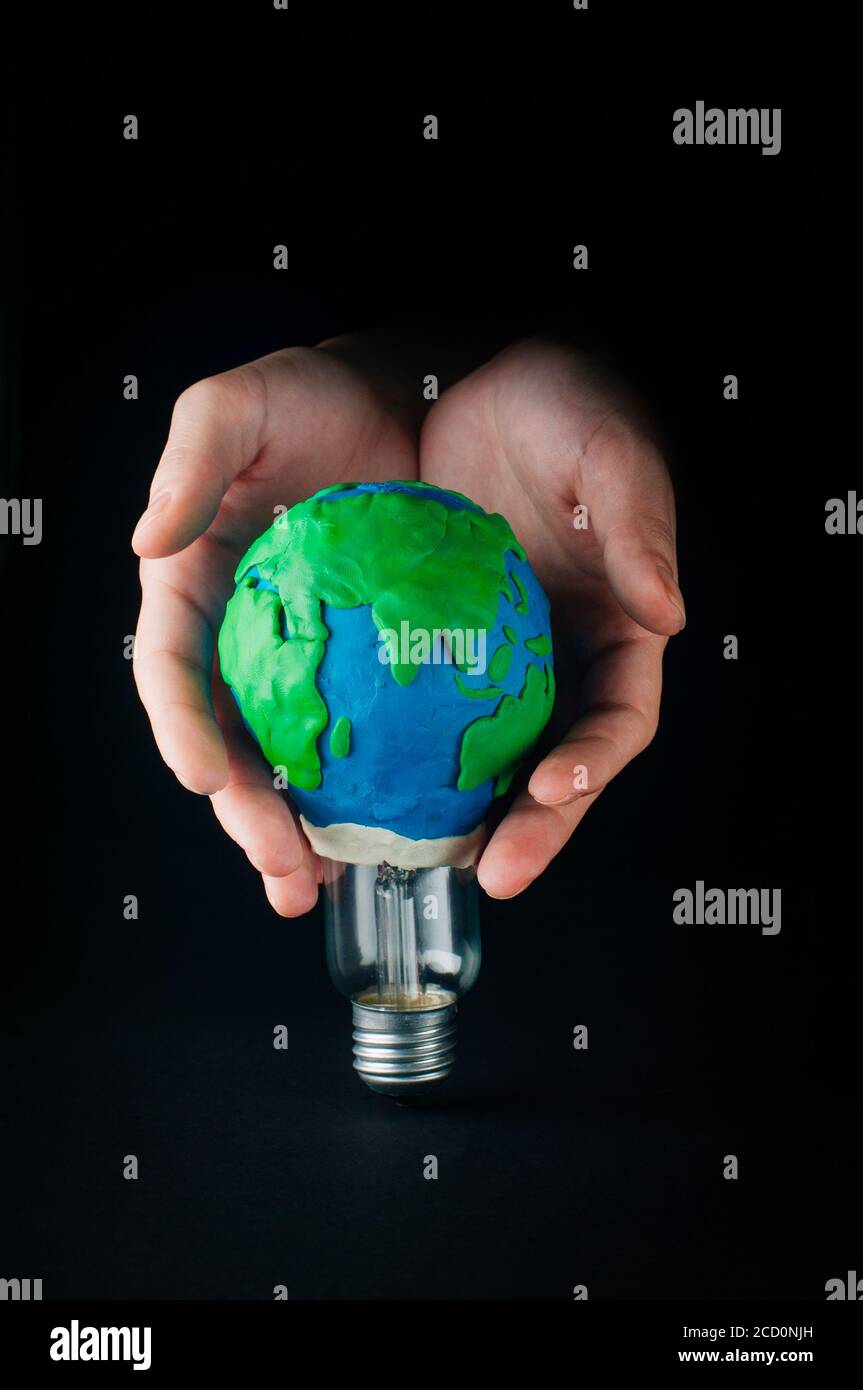 Earth Hour concept: male hands holding an electric lamp decorated as ...