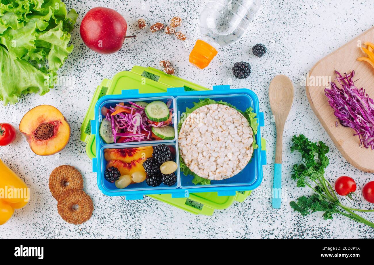 Healthy food concept. Open lunch box with sandwich, crispbreads, fruits ...